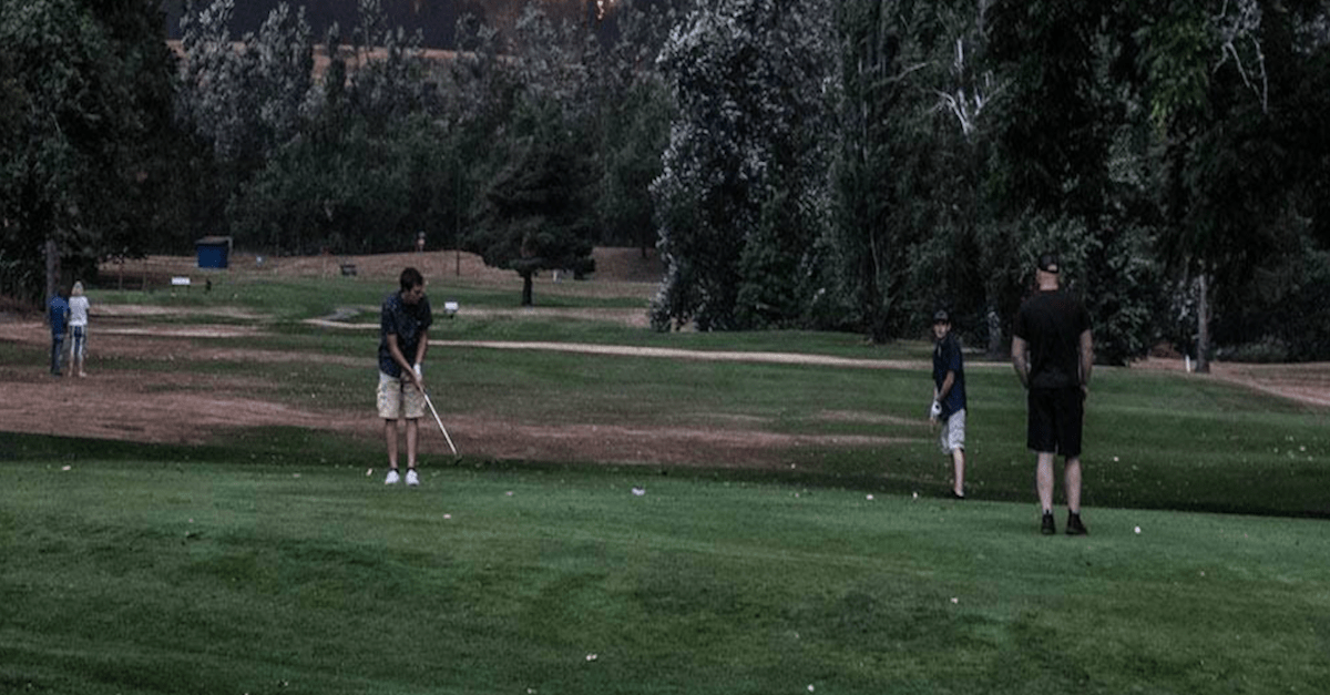 Incredible photos show golfers playing as wildfire rages behind them ...
